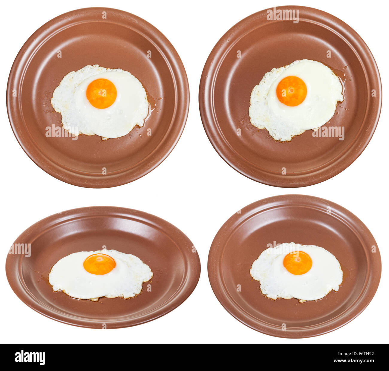 set of brown ceramic plates with one fried egg isolated on white ...