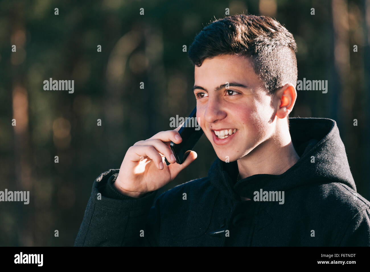 Portrait of teenage boy talking on his mobile phone Stock Photo - Alamy