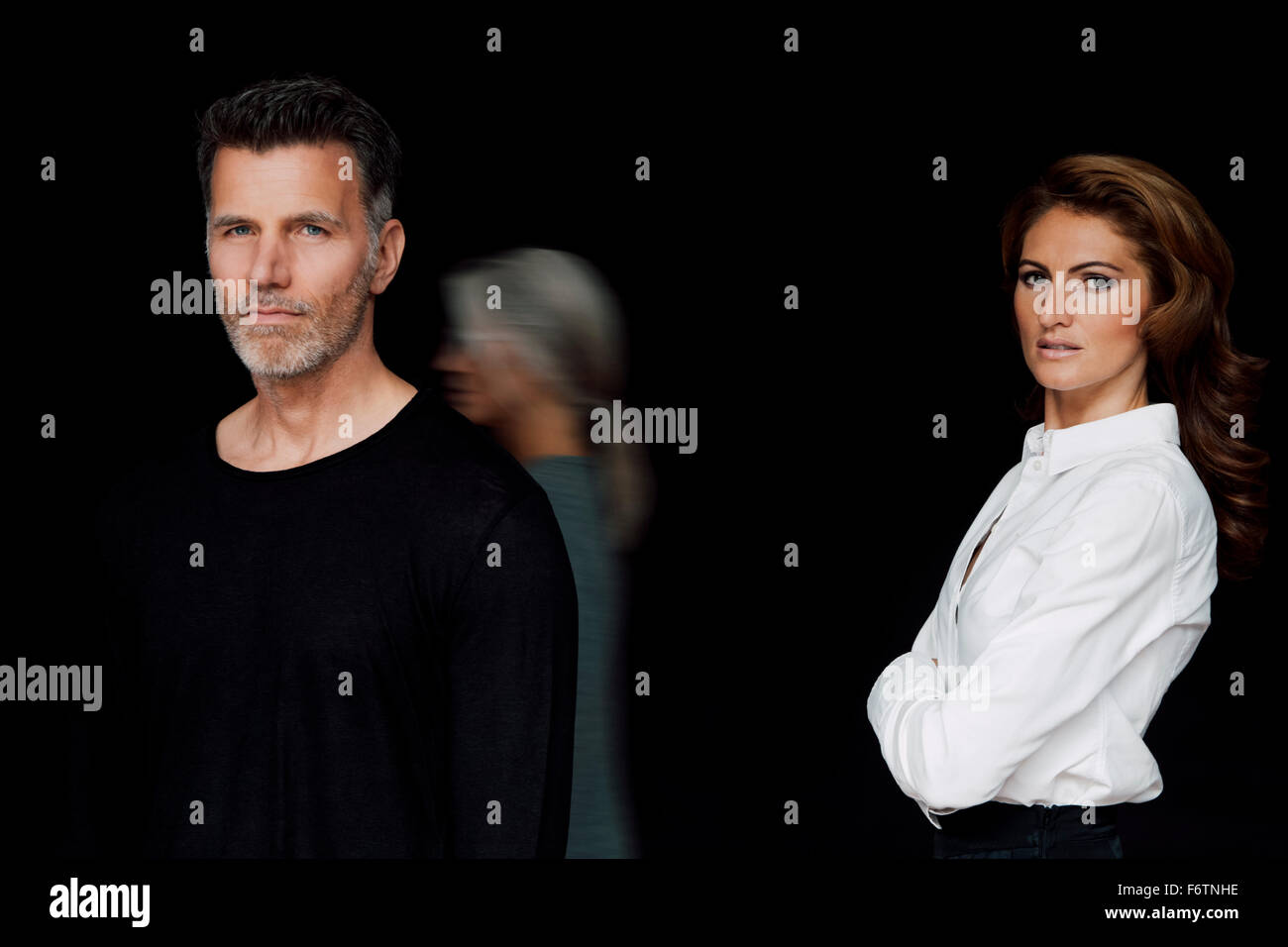 Portrait of serious looking business people in front of black ...