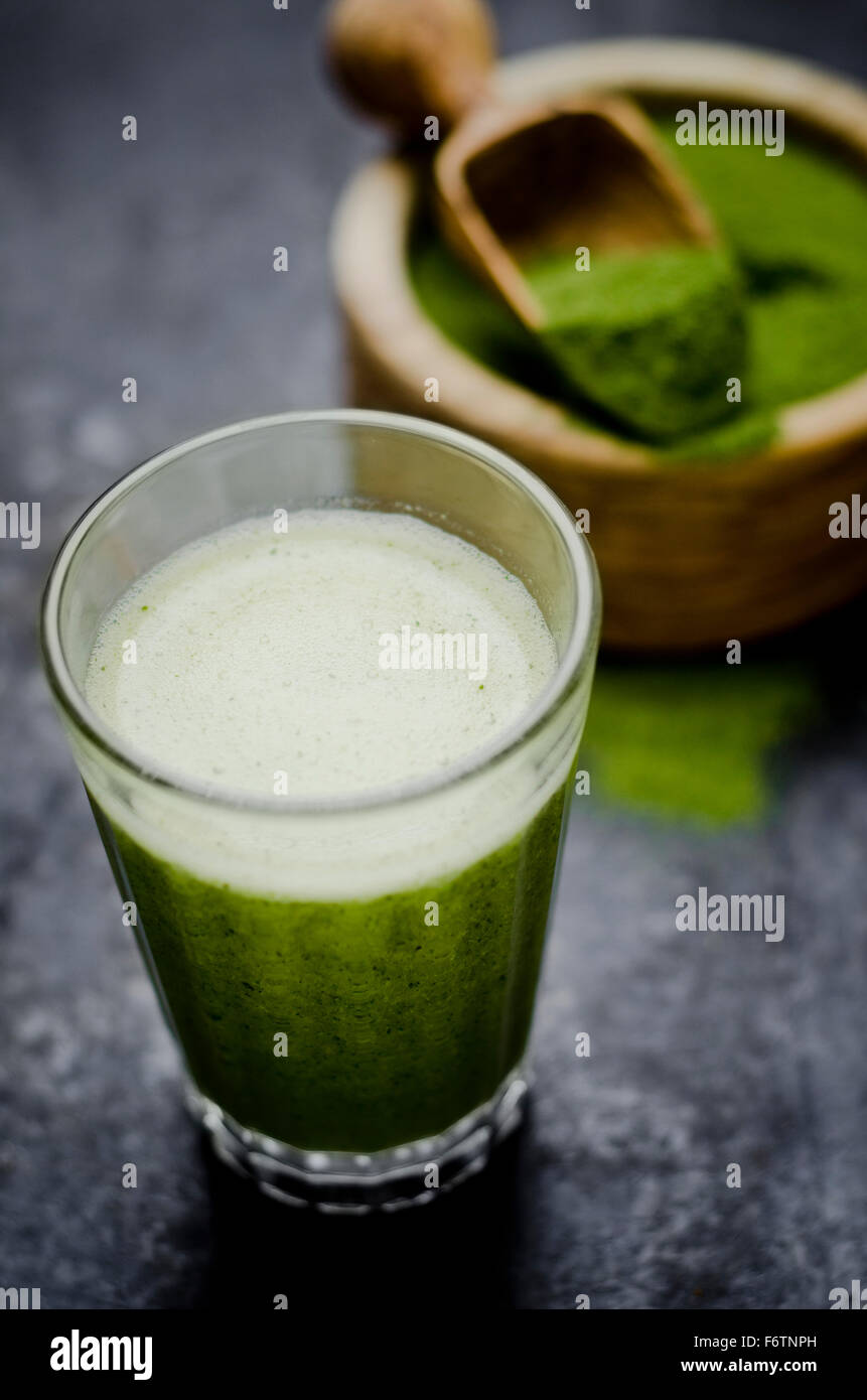 Moringa smoothie with orange and lemon juice, moringa powder in wooden ...