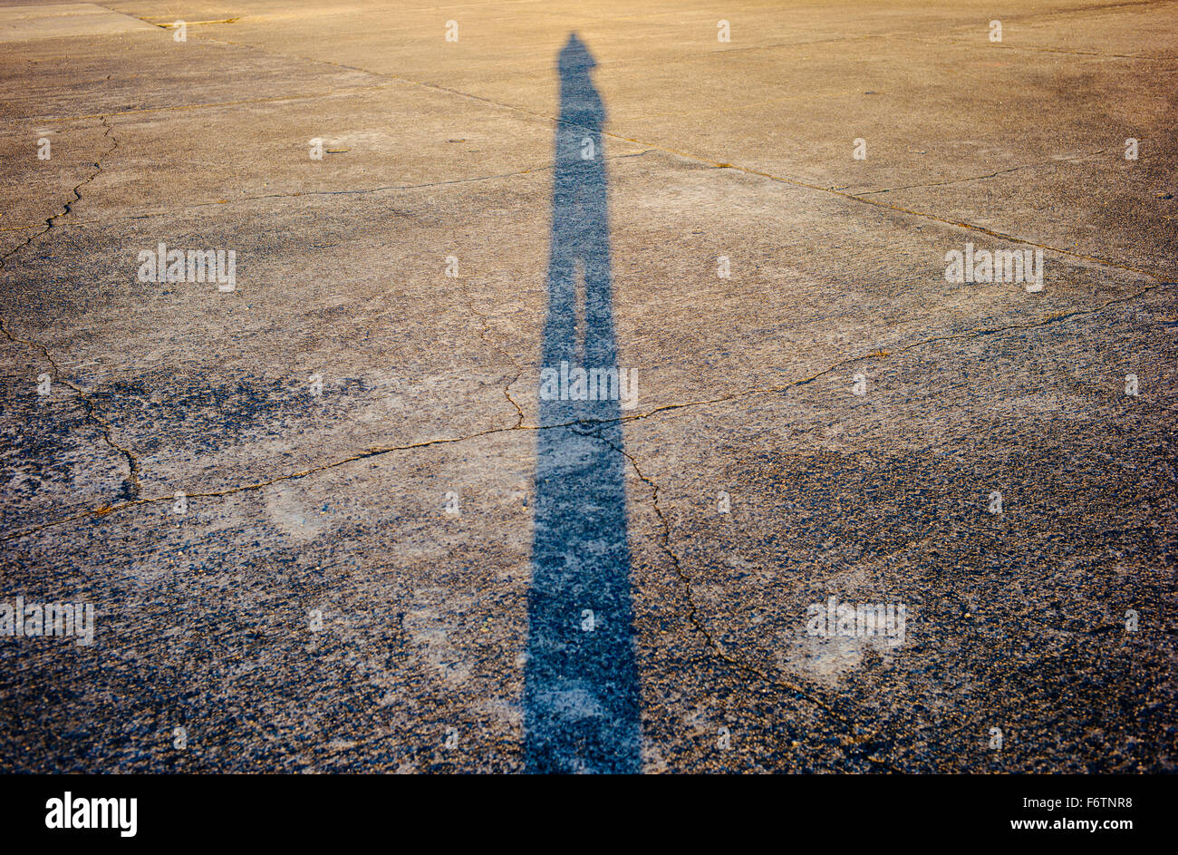 Shadow of person on cracked runway Stock Photo - Alamy