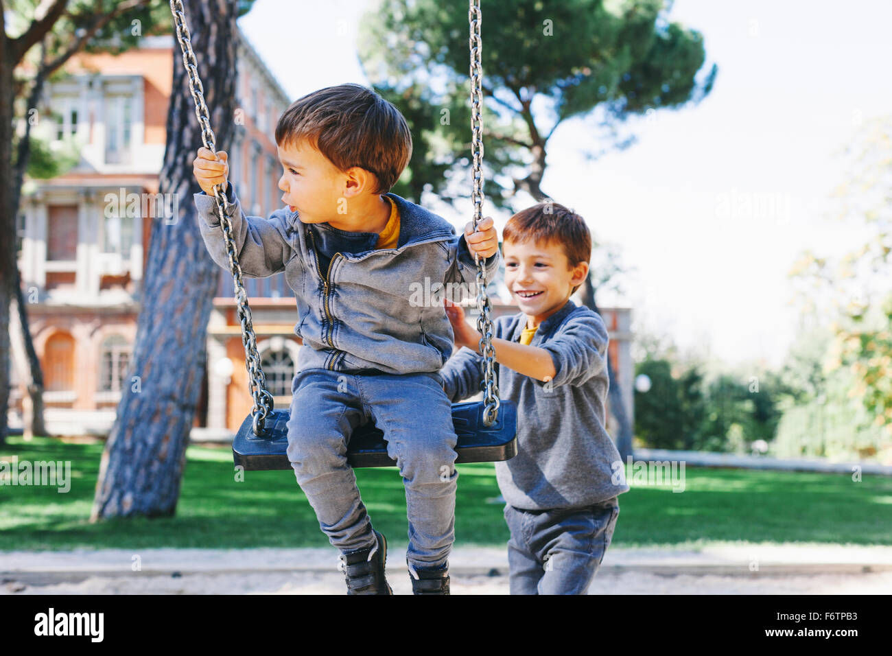 Brother pushing toddler on swing hi-res stock photography and images ...