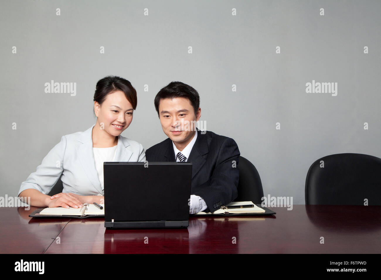 Businesspeople Working Together on Laptop Stock Photo - Alamy