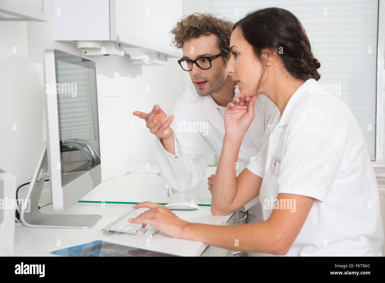 Two doctors at computer screen discussing Stock Photo - Alamy