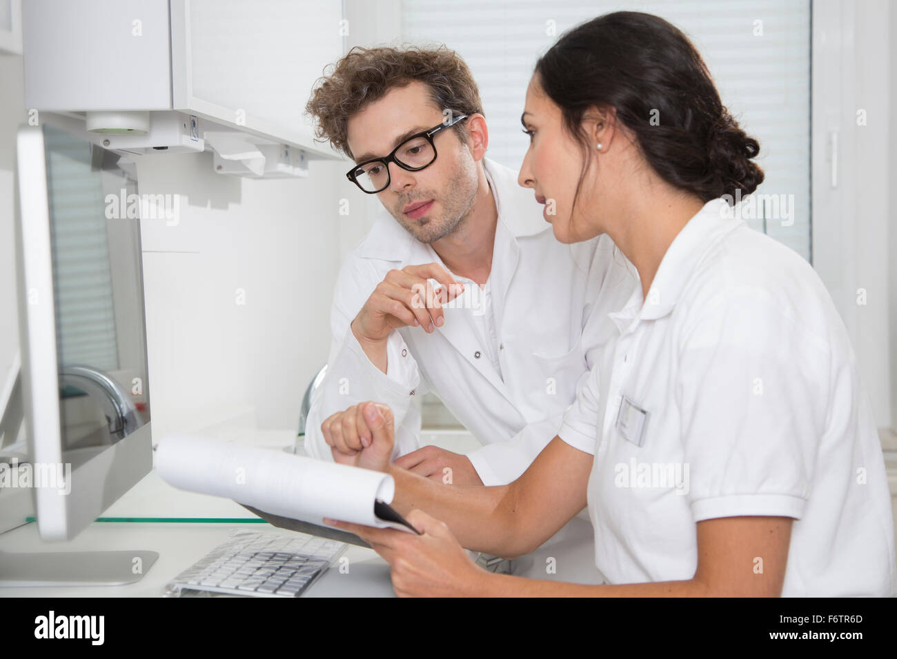Two doctors at desk discussing Stock Photo - Alamy