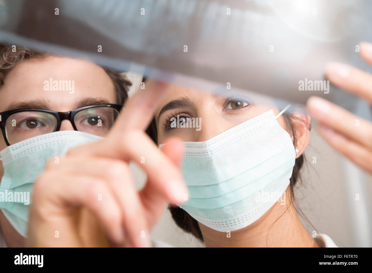 Two doctors with mouth masks looking at x-ray image Stock Photo - Alamy