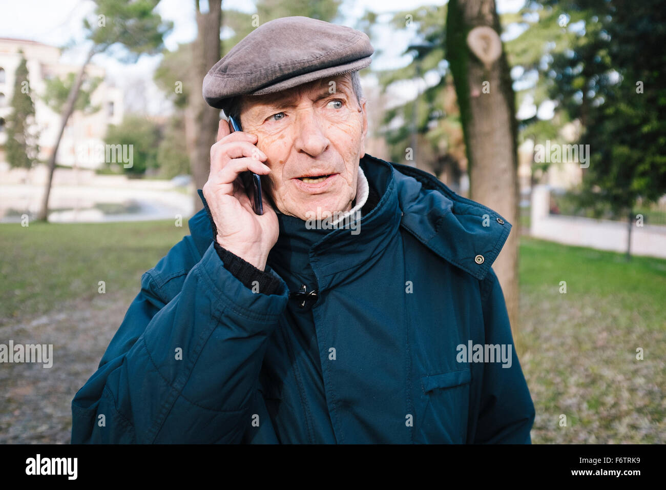 Portrait of senior man telephoning with smartphone in a park Stock ...
