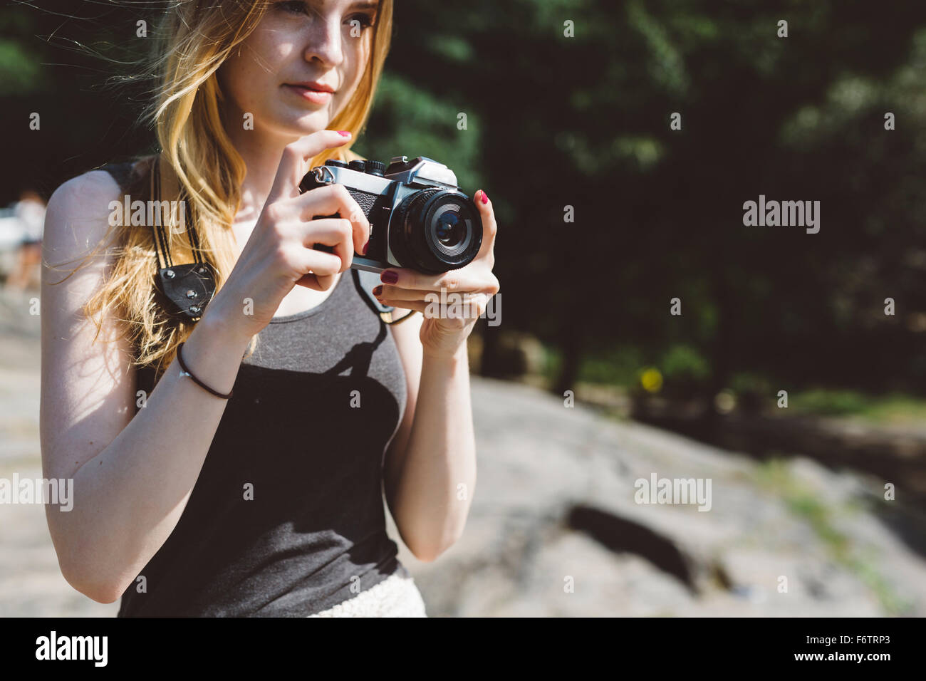 Young woman outdoors with camera Stock Photo - Alamy