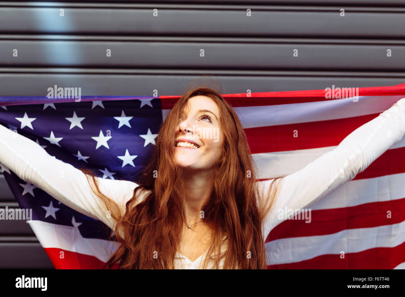 Smiling woman holding an American flag with confidence Stock Photo - Alamy