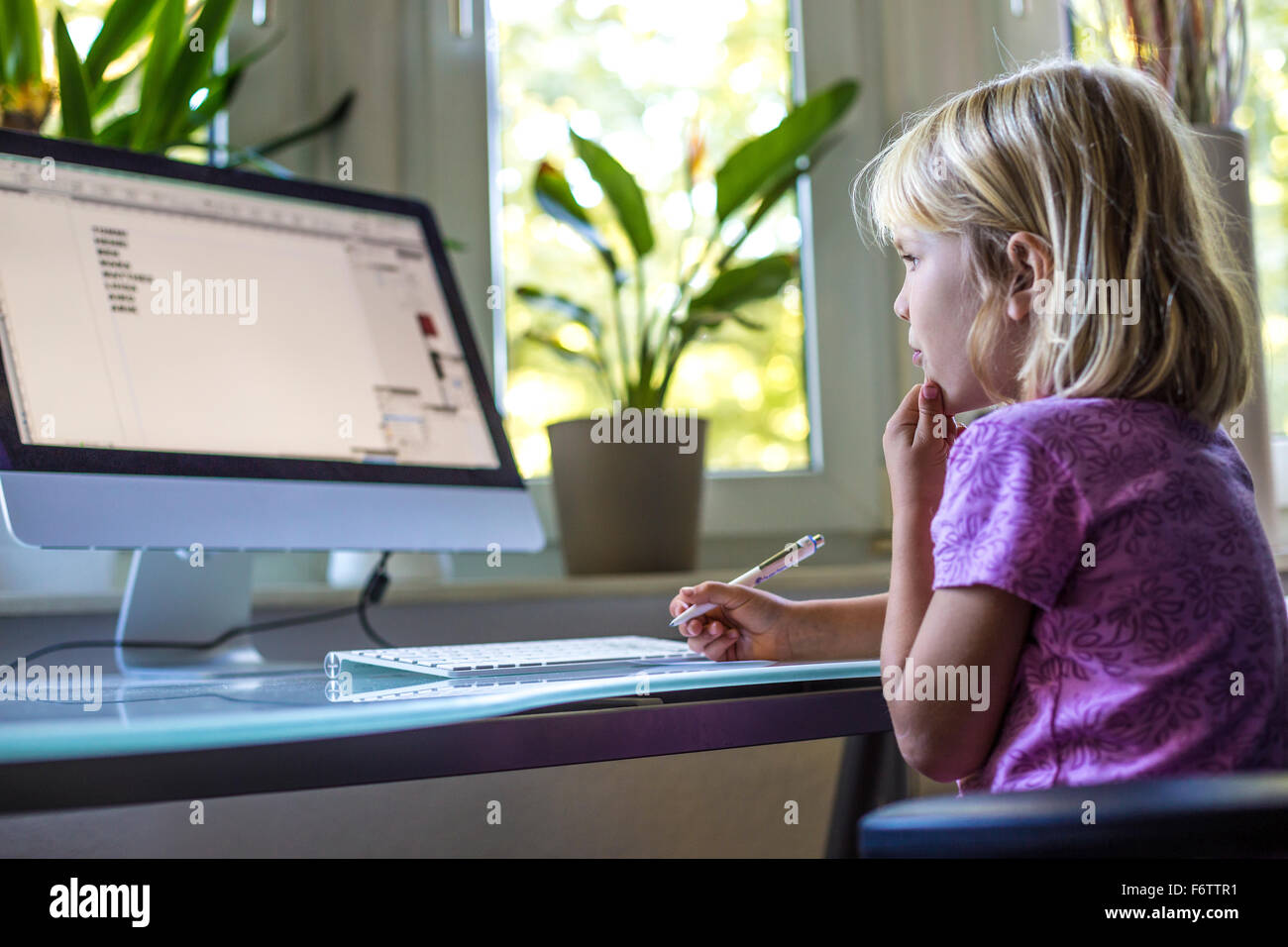 Little girl looking at computer monitor at home Stock Photo - Alamy
