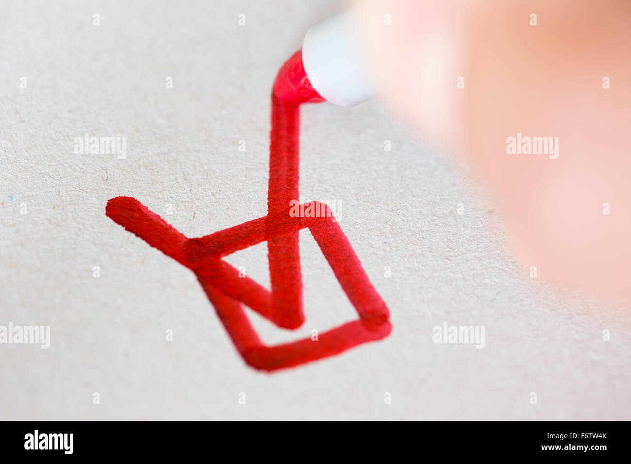 Hand with red pen marking a check box Stock Photo - Alamy