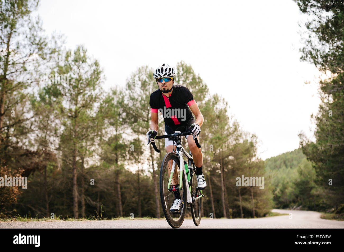 Cyclist riding a bike on a road Stock Photo - Alamy
