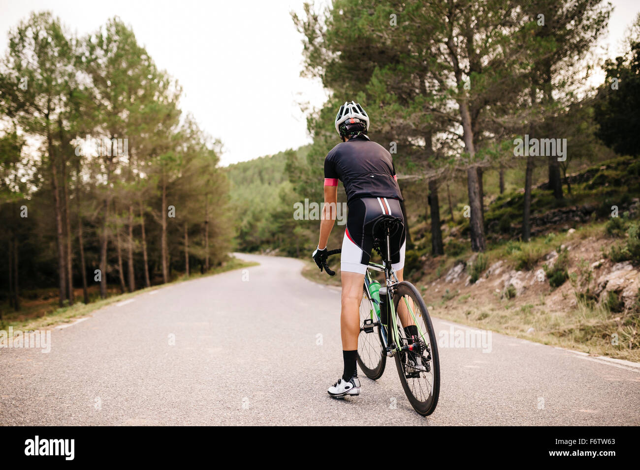 Cyclist with racing cycle on a road Stock Photo - Alamy