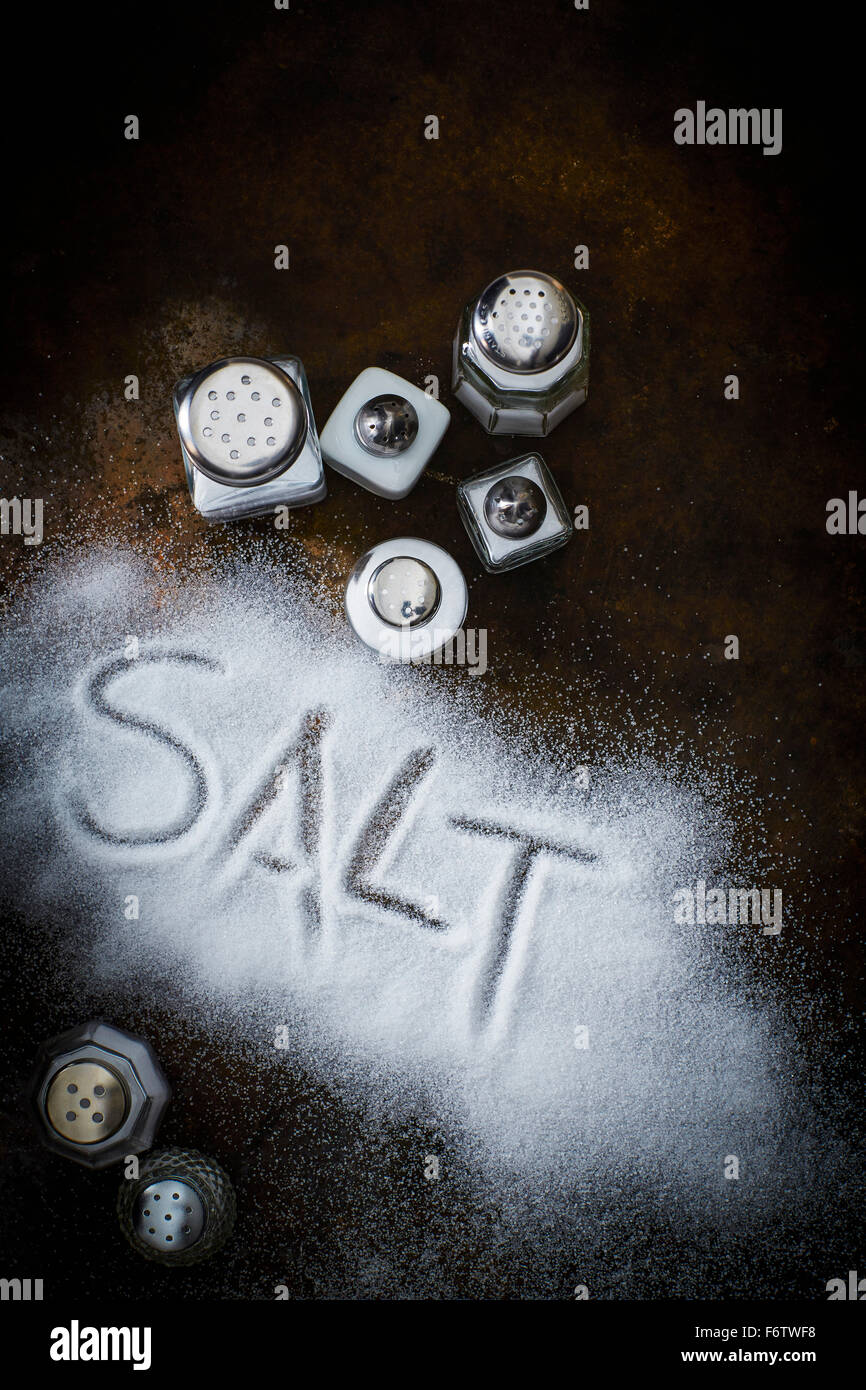 Different salt shakers and the word 'salt' written in salt Stock Photo ...