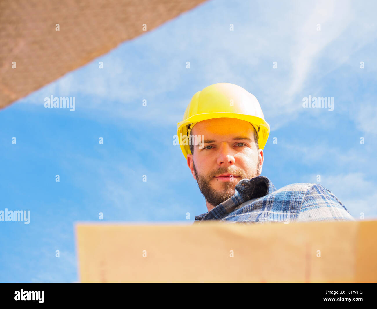 Portrait of foreman with construction plan in front of sky Stock Photo ...