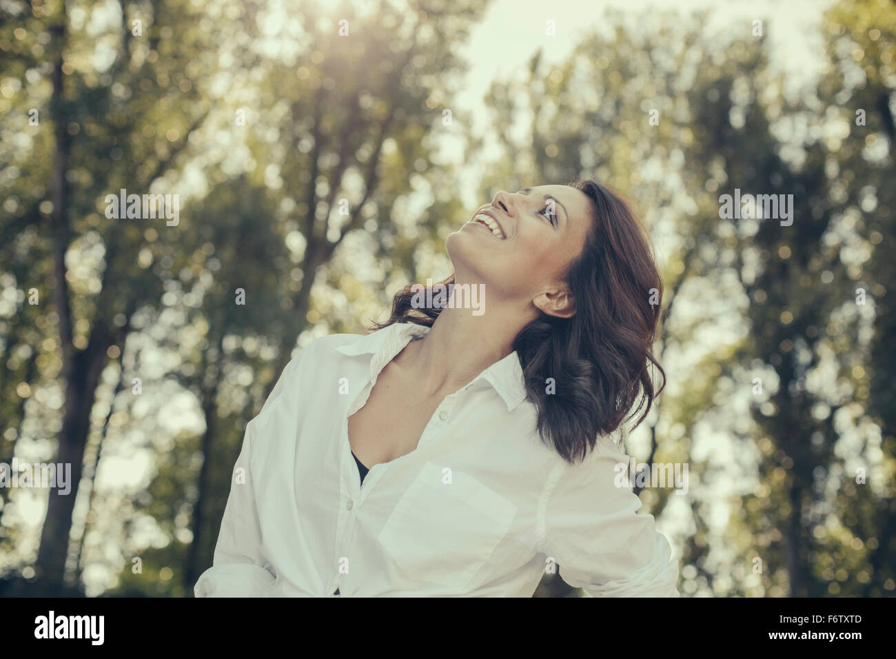 Portrait of smiling woman in nature looking up Stock Photo - Alamy