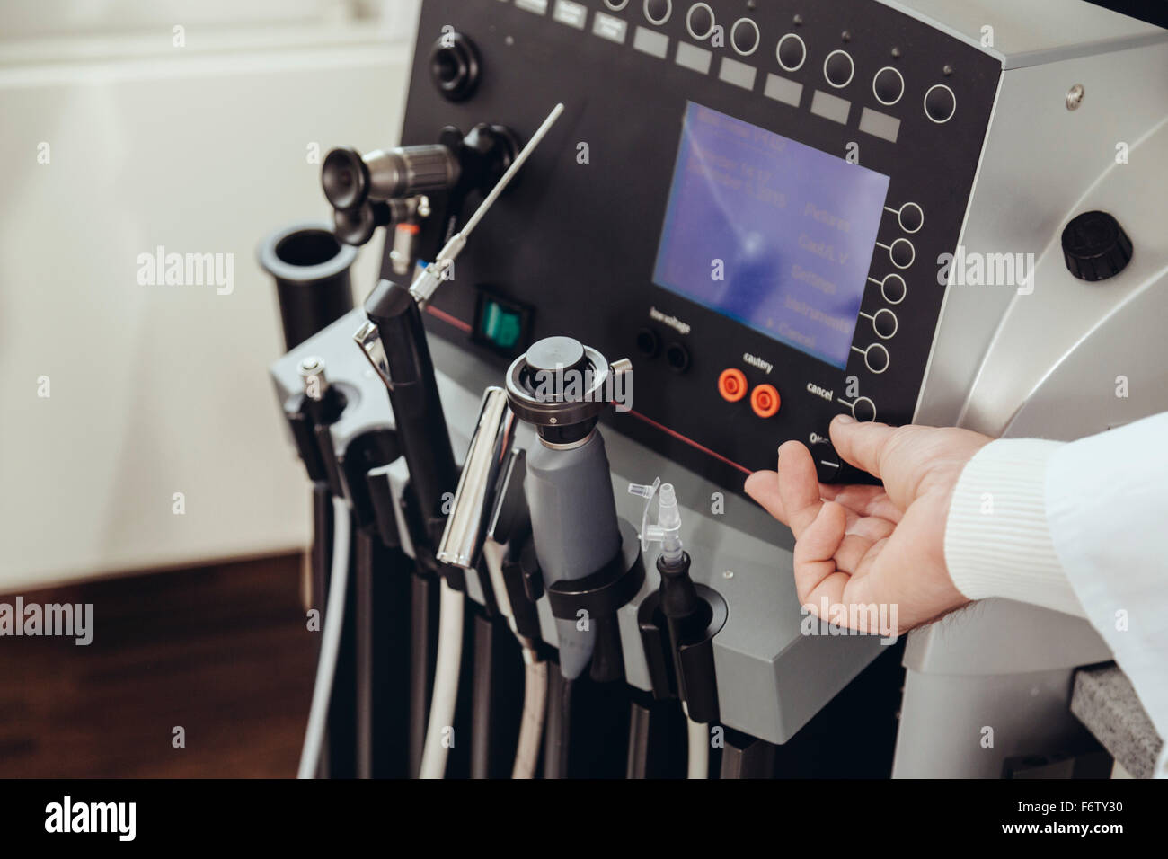 ENT doctor turning a knob at medical device in practice Stock Photo - Alamy
