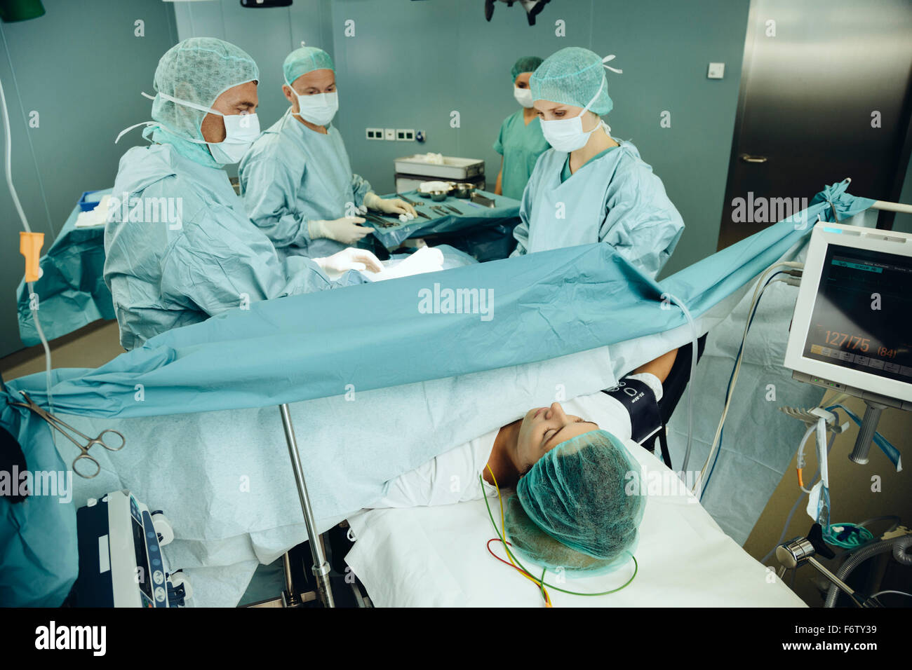 Team operating a woman on surgery table Stock Photo - Alamy