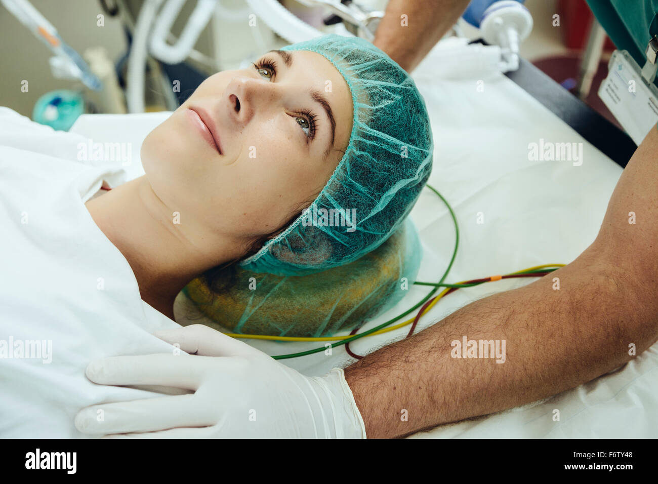 Operating nurse soothing patient on table in operating room Stock Photo ...