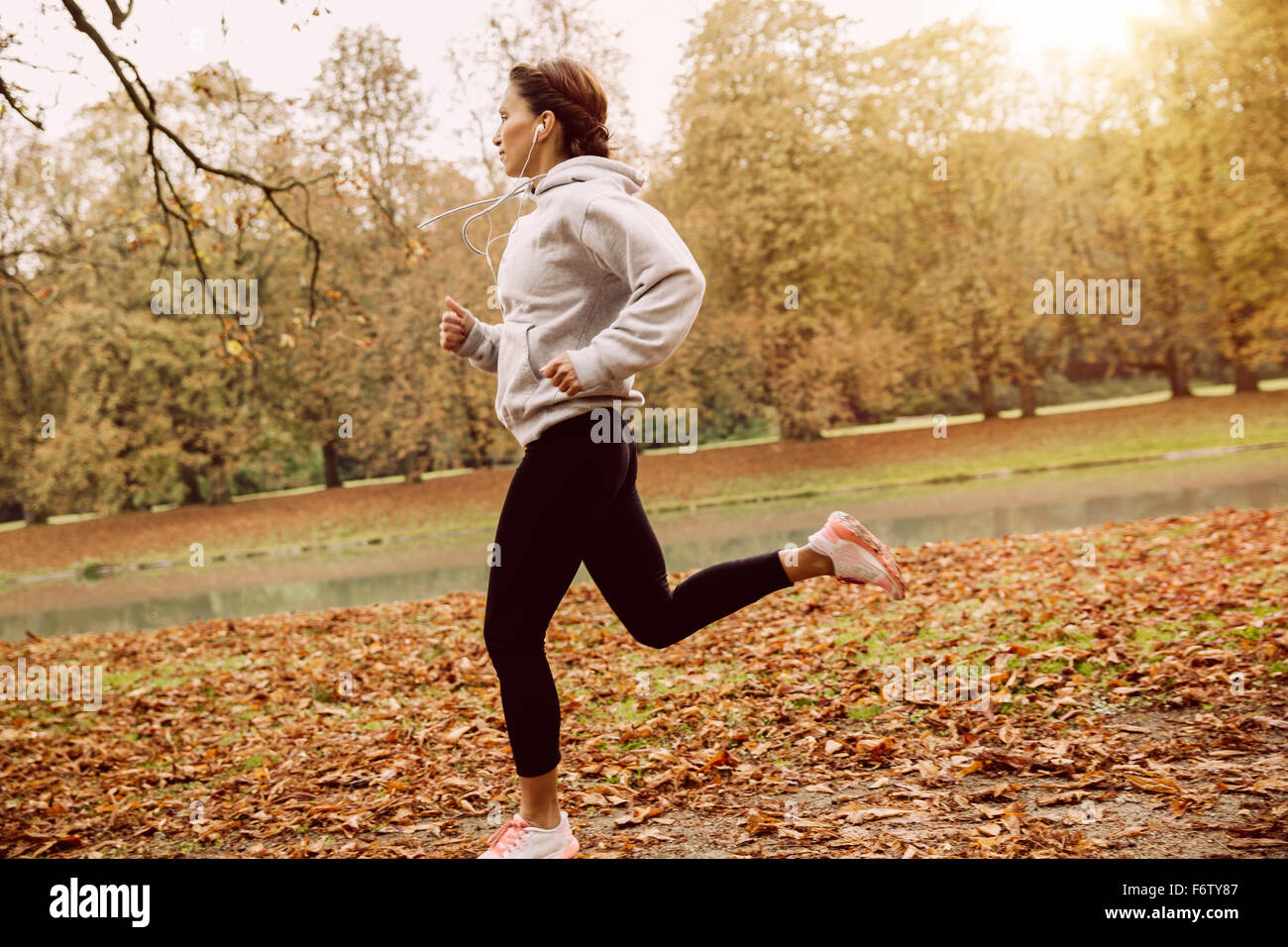 Woman jogging in park during autumn Stock Photo - Alamy