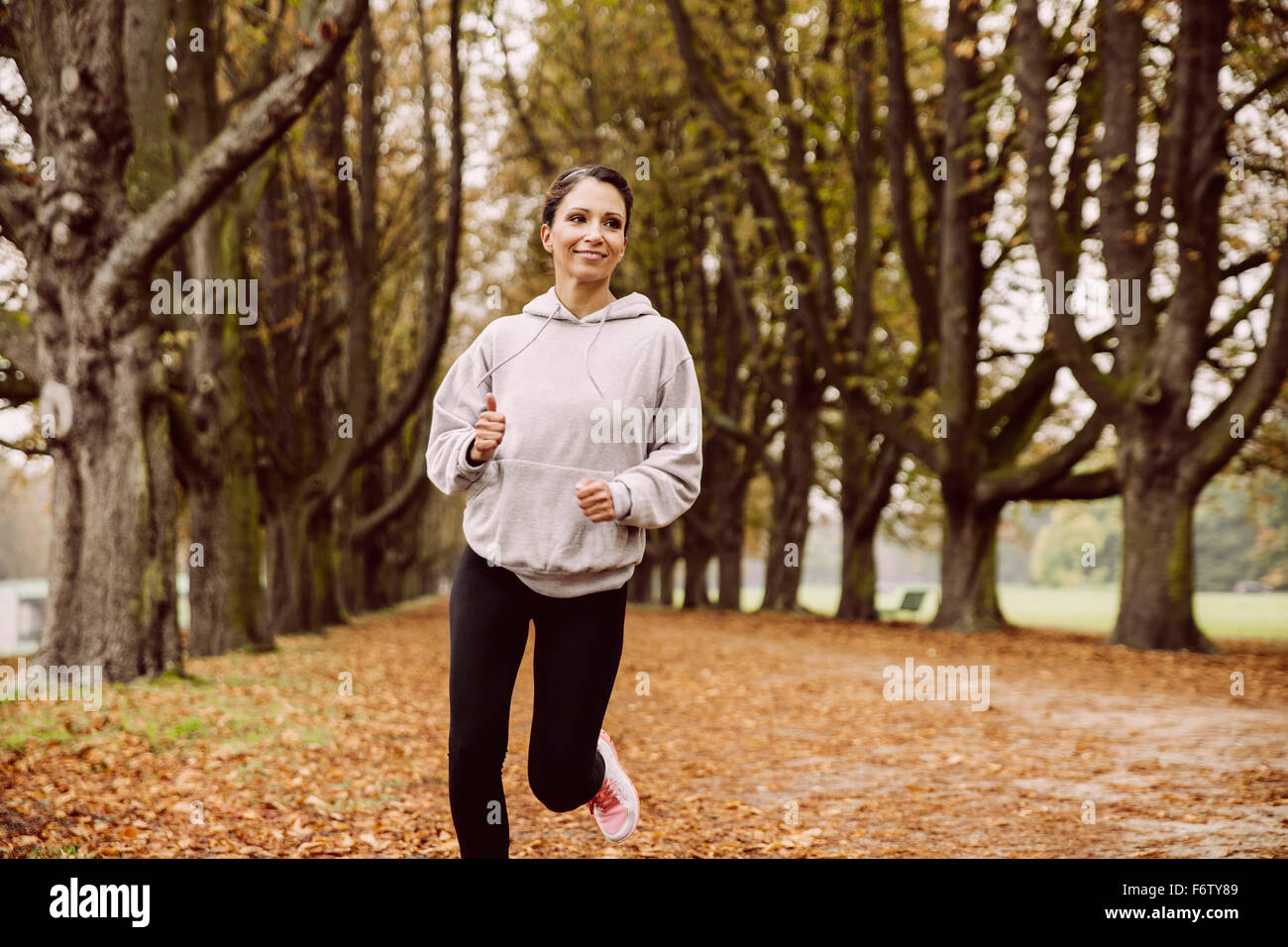 Woman jogging in park during autumn Stock Photo - Alamy