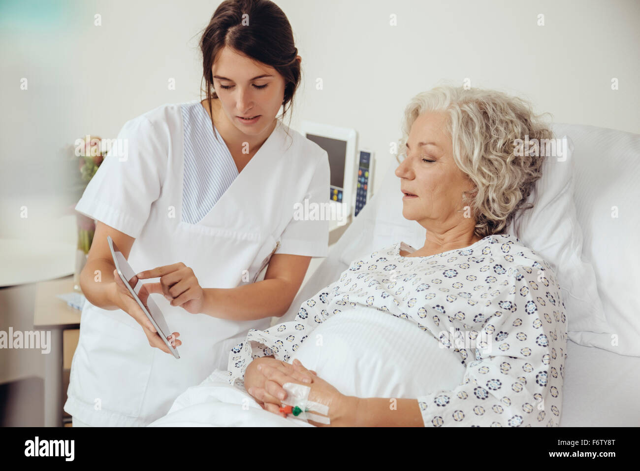 Nurse explaining senior woman in hospital digital tablet Stock Photo ...