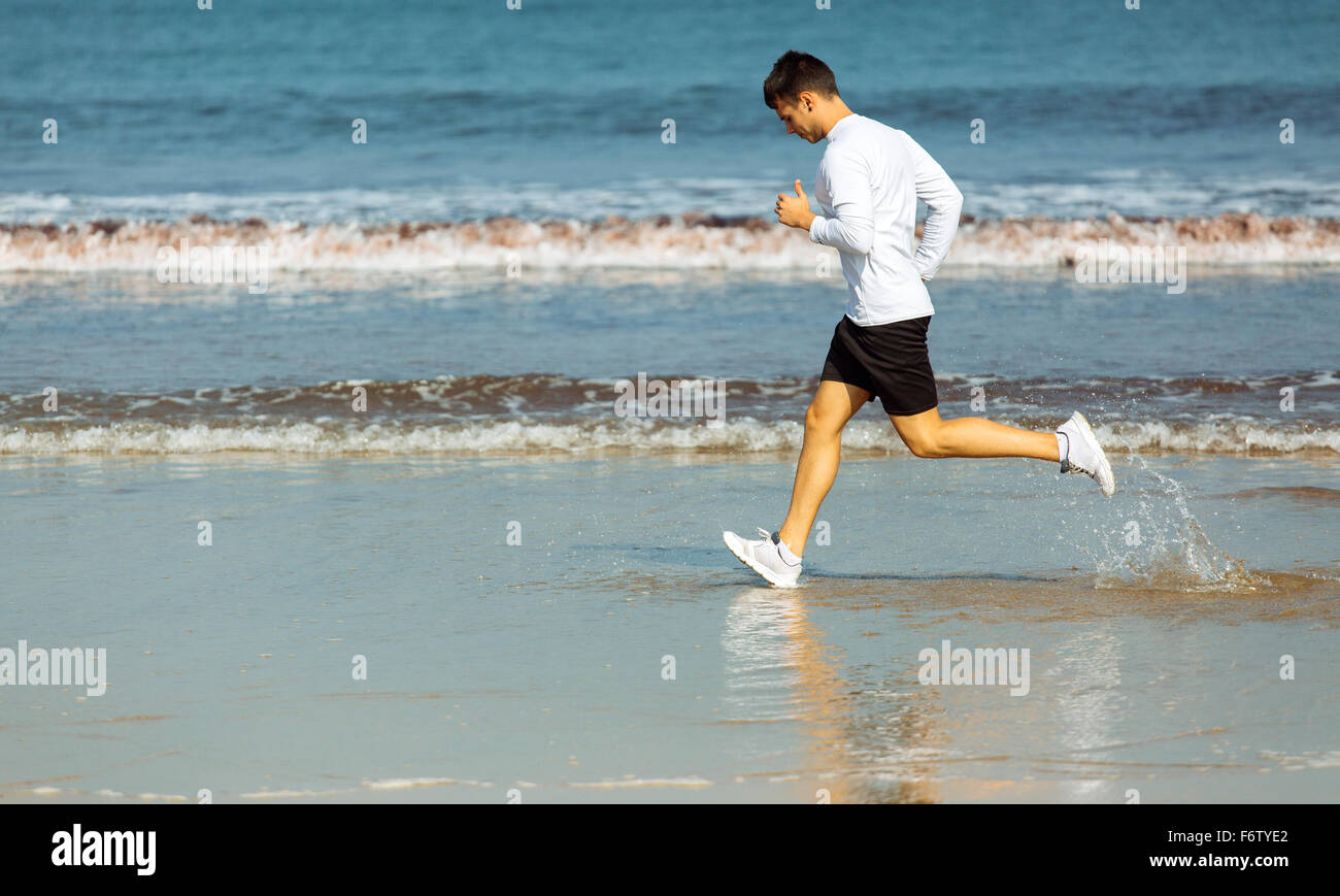 Spain, Asturias, Gijon, young man running on the beach Stock Photo - Alamy