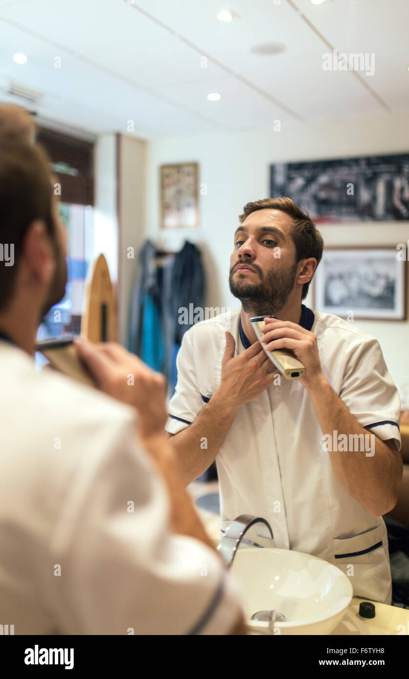 Barber shaving his beard in a barber shop Stock Photo - Alamy