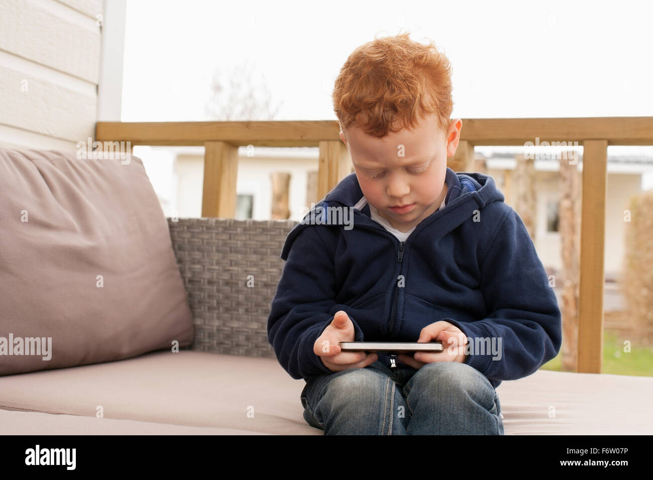 Little boy looking at cell phone Stock Photo - Alamy