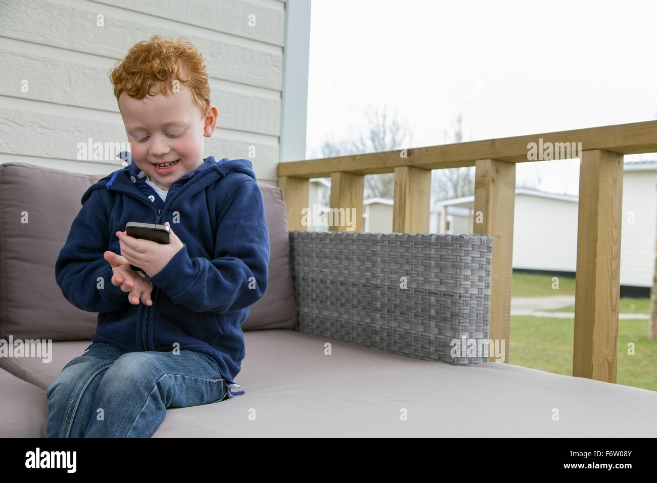 Smiling little boy looking at cell phone Stock Photo - Alamy