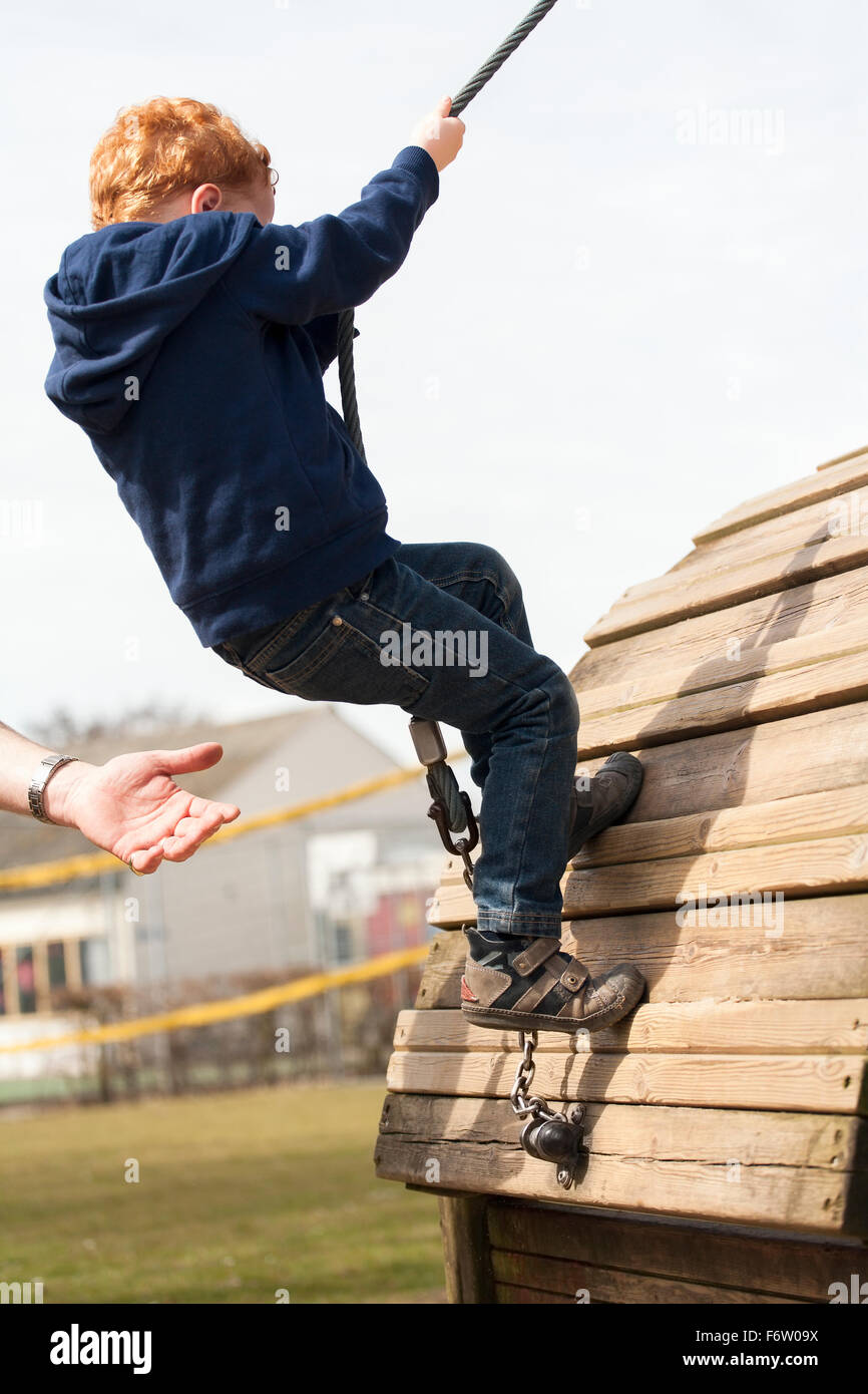 Boy on playground with helping hand at his side Stock Photo - Alamy