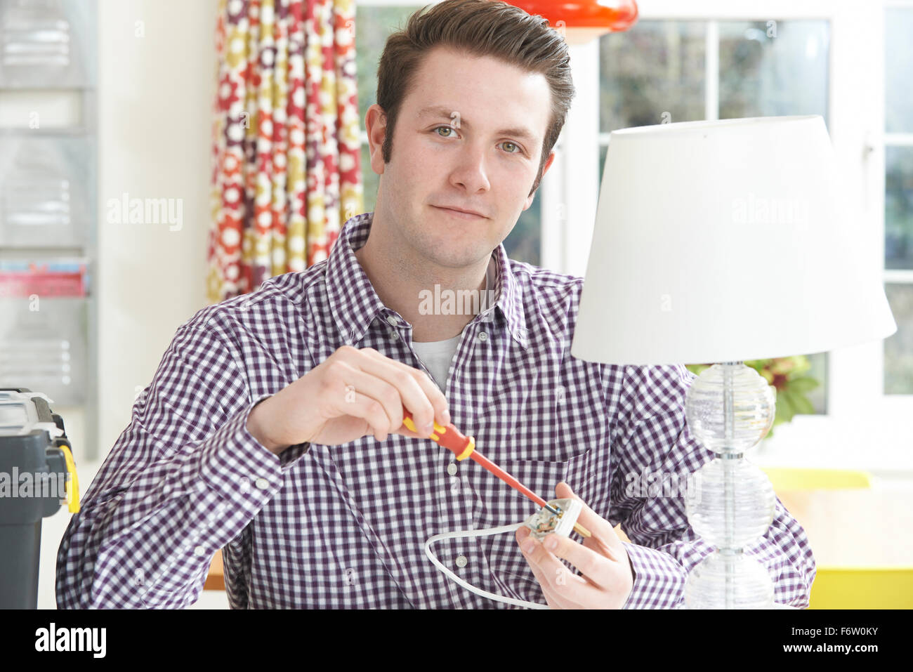 Man Wiring Electrical Plug On Lamp At Home Stock Photo - Alamy