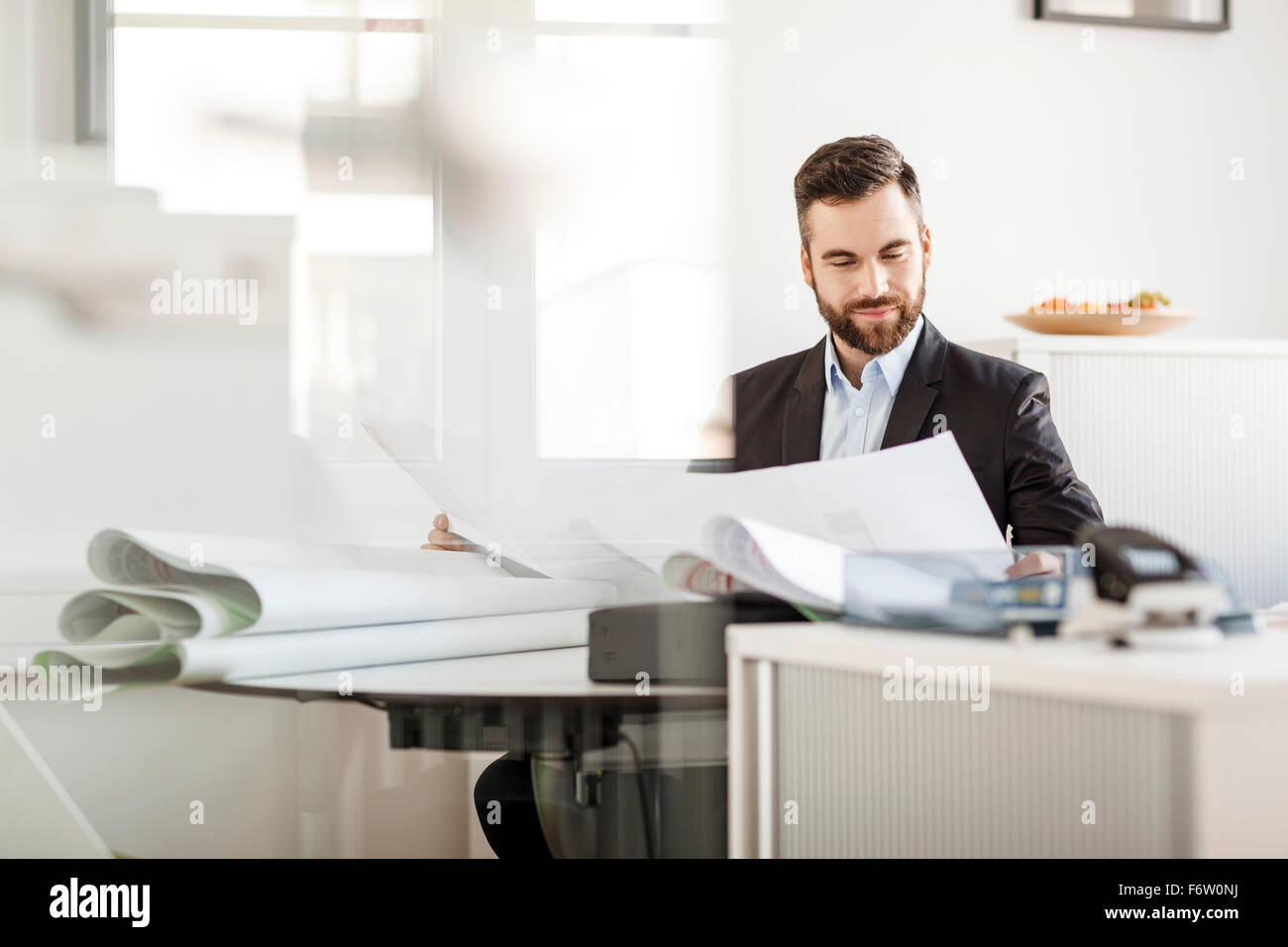 Man in office looking at construction plan Stock Photo - Alamy