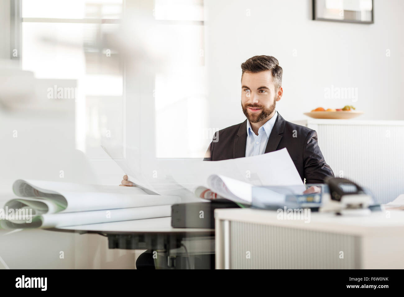 Man in office holding construction plan Stock Photo - Alamy