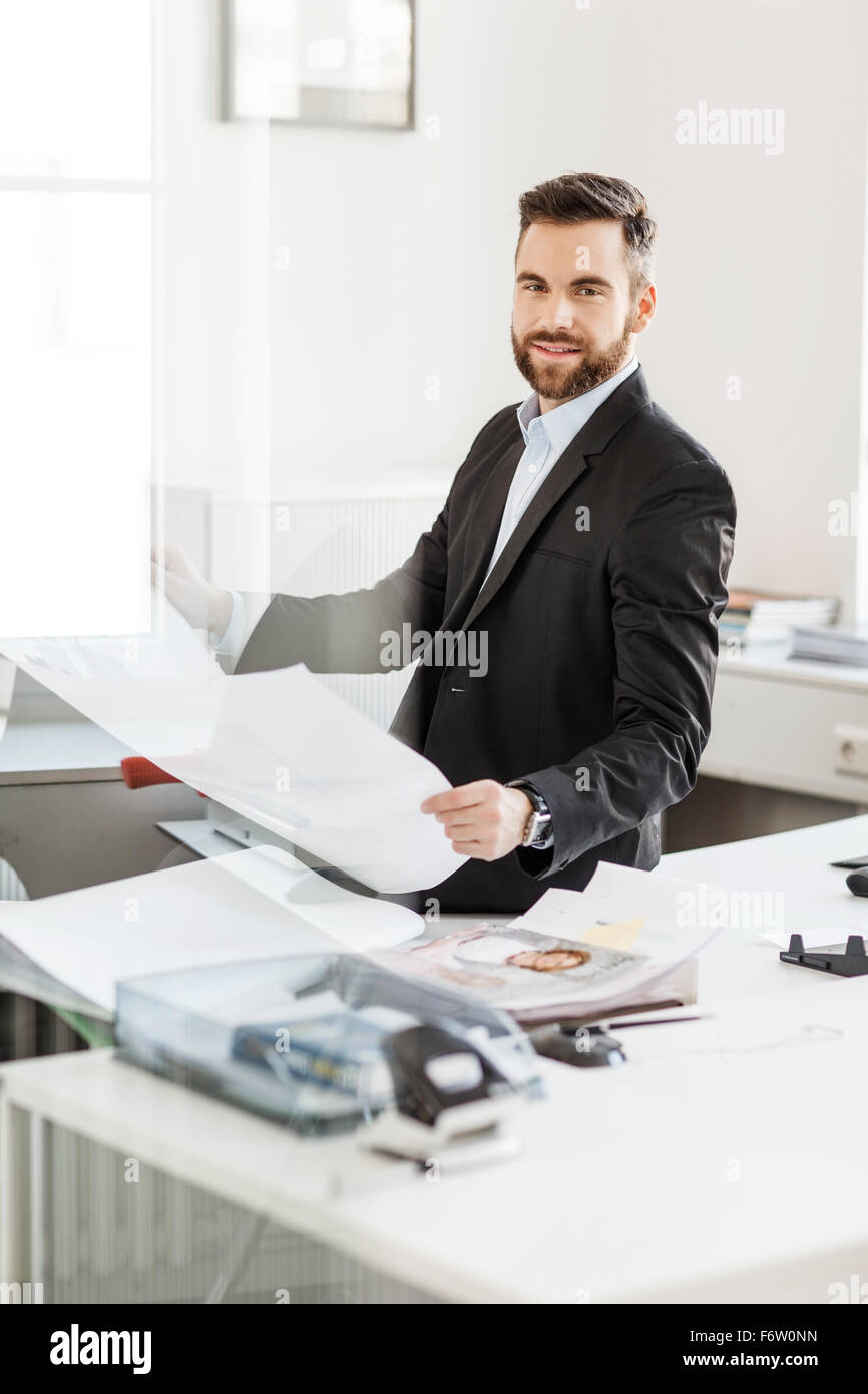 Man in office holding construction plan Stock Photo - Alamy