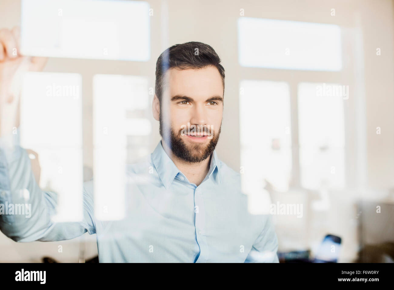 Portrait of businessman behind glass wall Stock Photo - Alamy