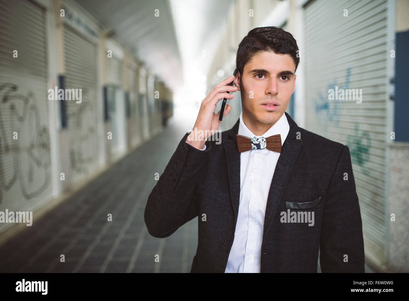 Young man on the phone wearing jacket and a wooden bow tie Stock Photo ...