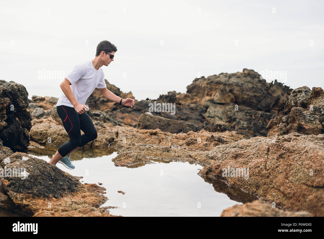 Spain, Ferrol, jogger ready to leap over water at the coast Stock Photo ...