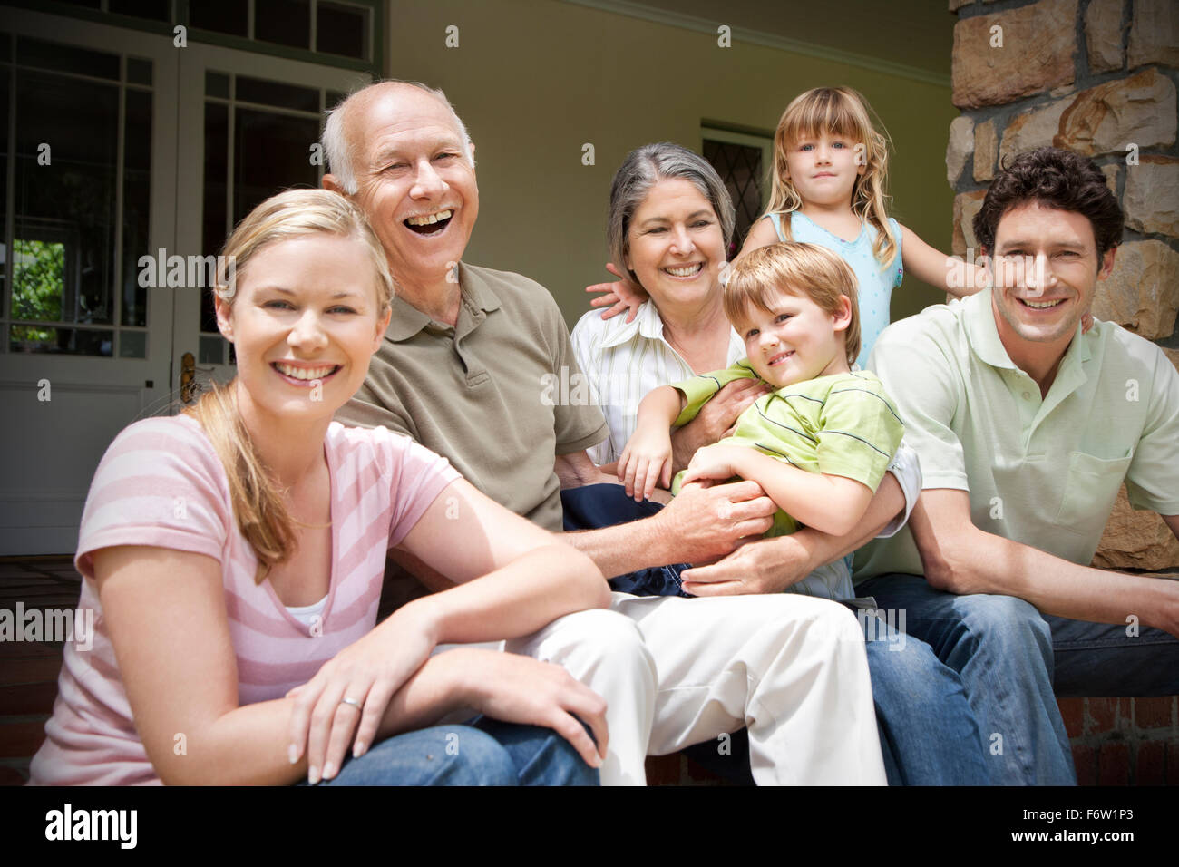 Group picture of three generations family sitting on the terrace Stock ...