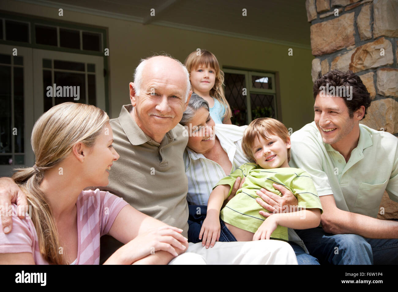 Group picture of three generations family sitting on the terrace Stock ...