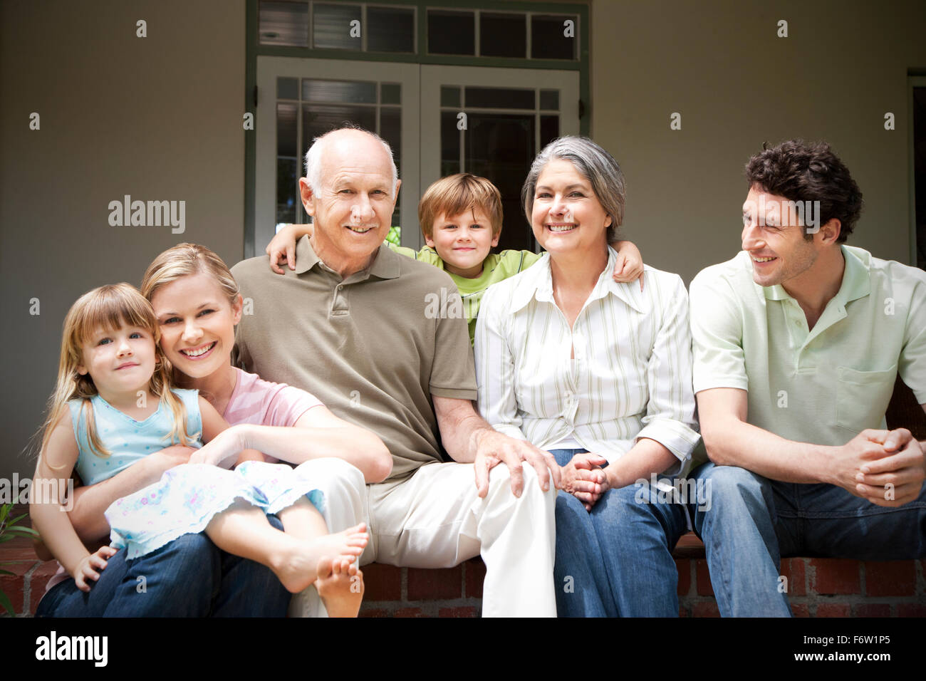 Group picture of three generations family sitting on the terrace Stock ...
