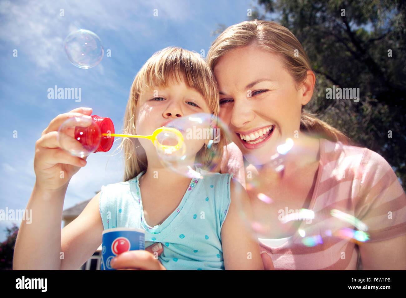 Woman and her little daughter blowing soap bubbles Stock Photo - Alamy