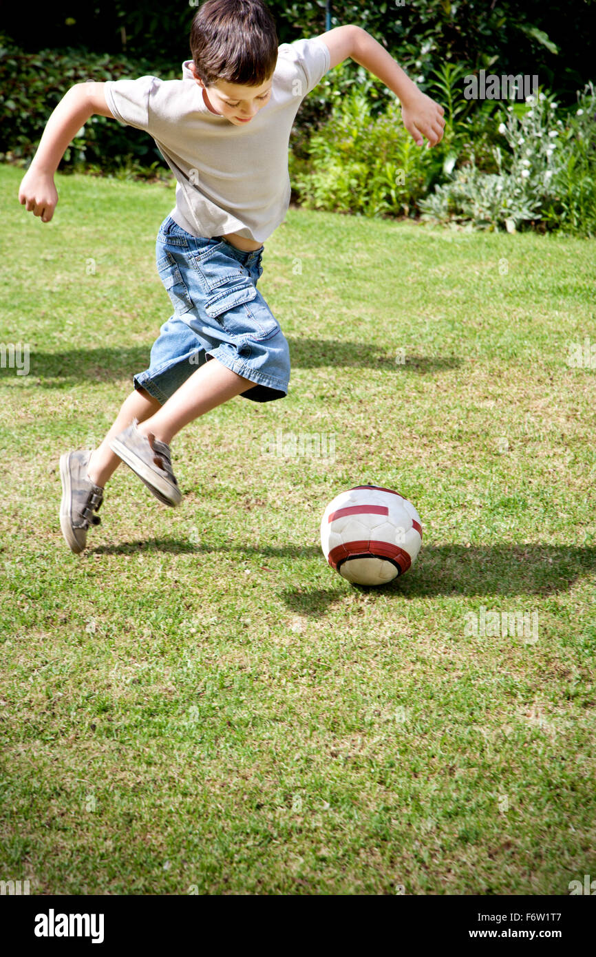 Little boy playing soccer in the garden Stock Photo - Alamy