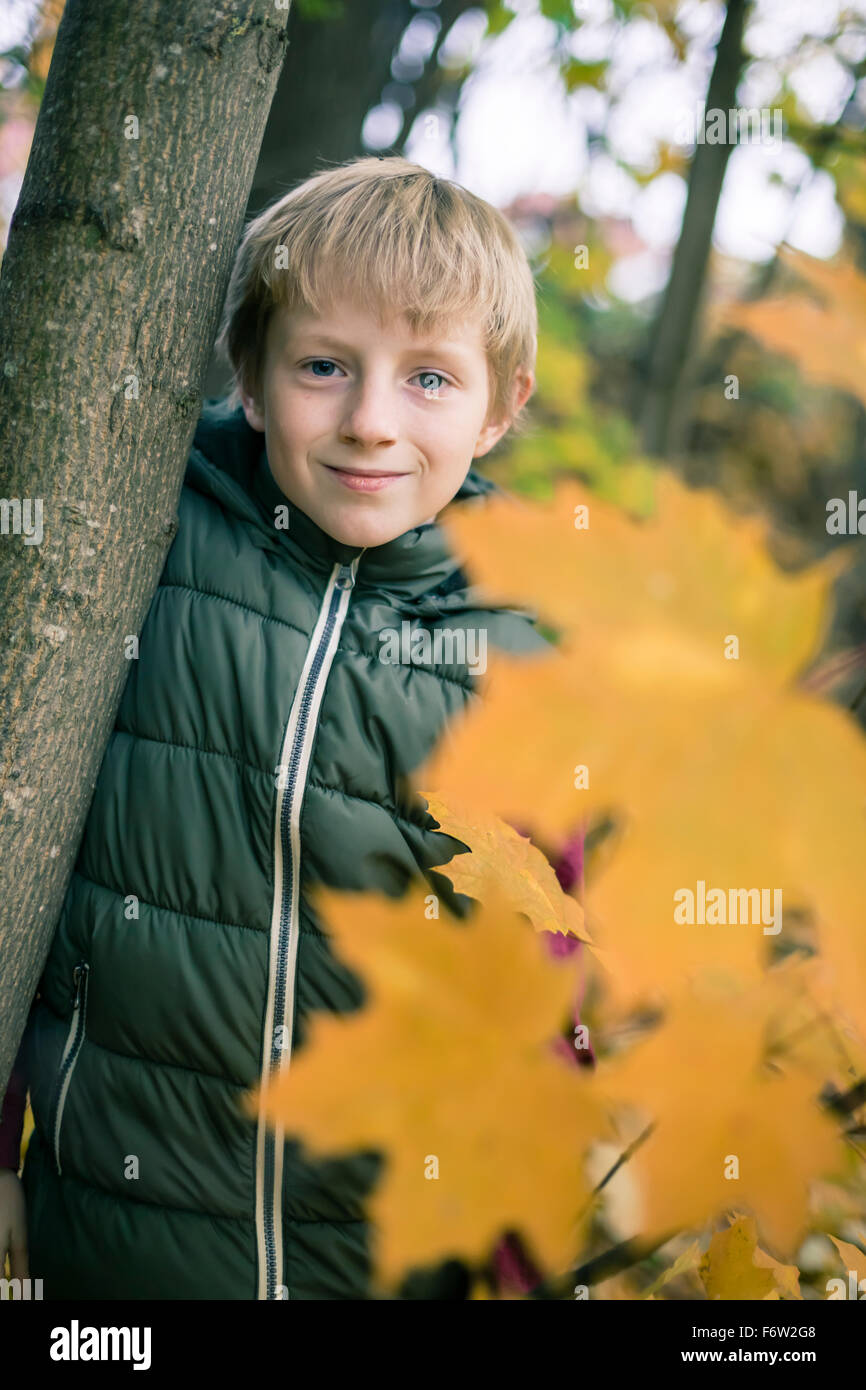 Boy leaning against tree hi-res stock photography and images - Alamy