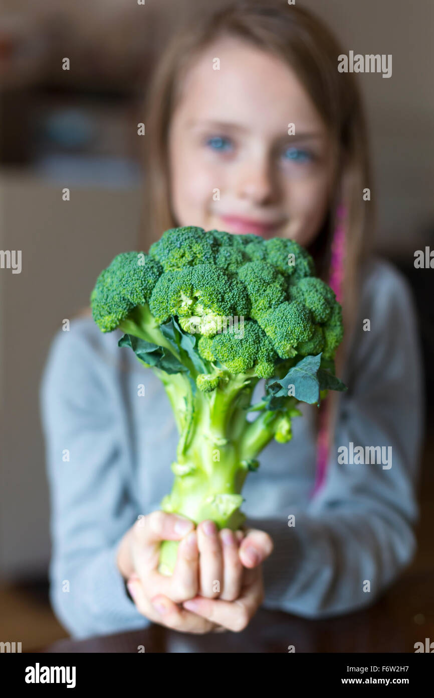 Girl holding broccoli Stock Photo - Alamy