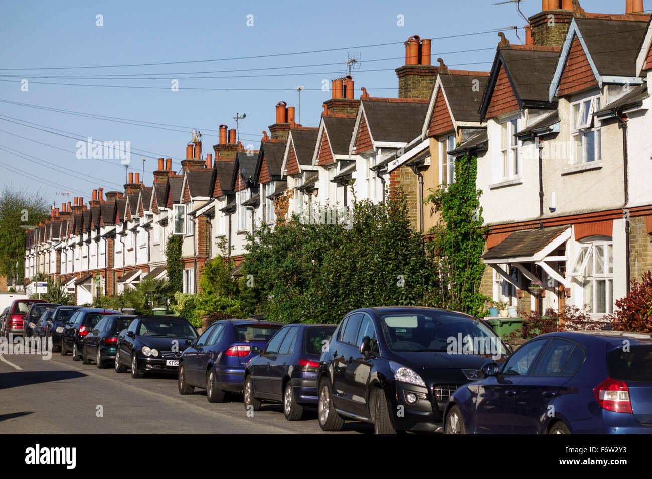 Typical suburban terraced houses and parked cars along the street ...