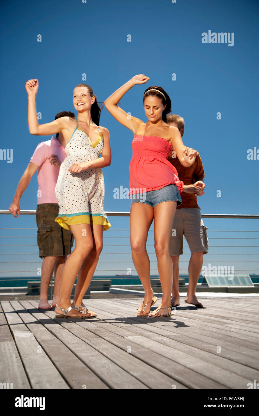 Happy friends dancing on wooden terrace Stock Photo - Alamy