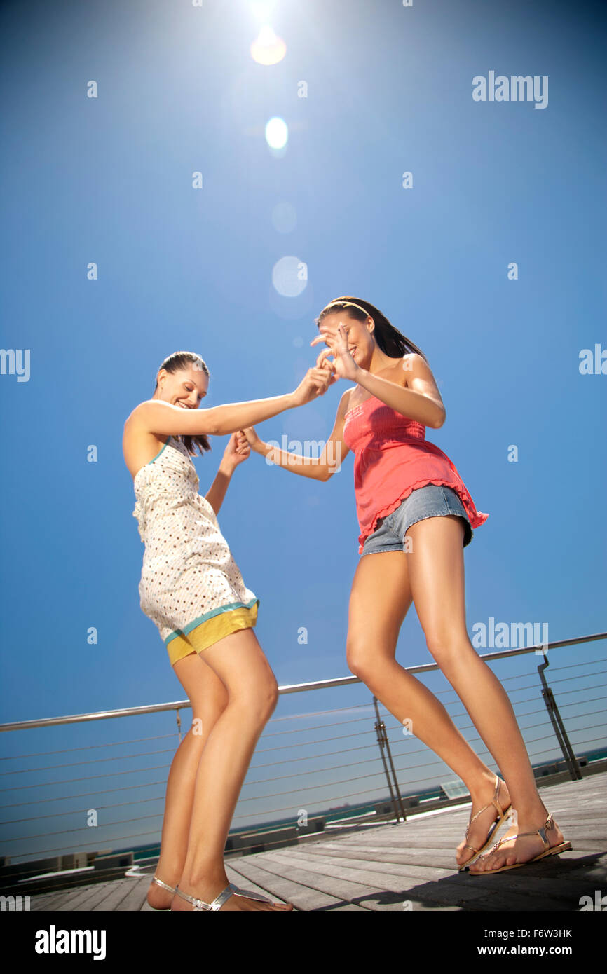 Two happy friends dancing on wooden terrace Stock Photo - Alamy