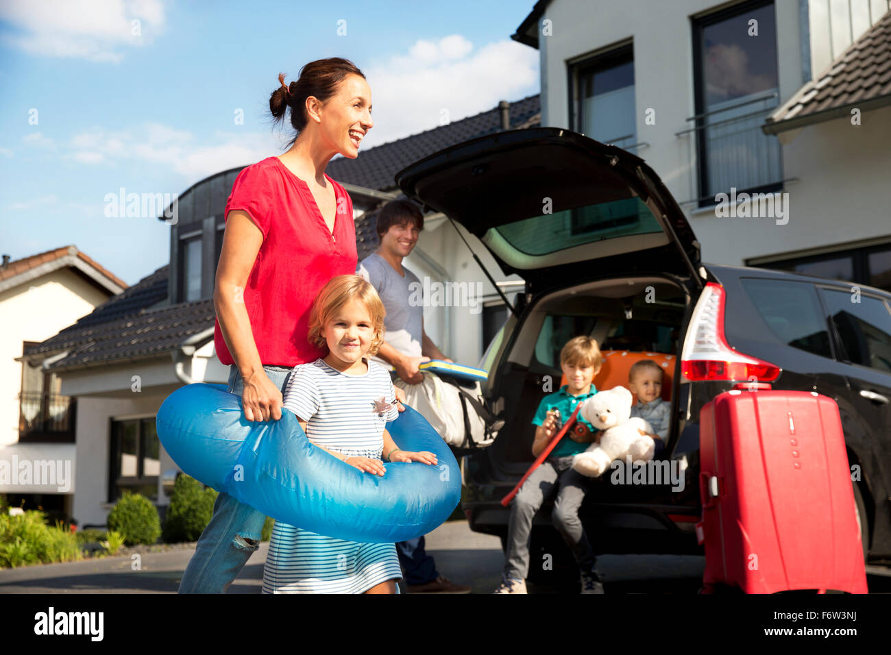 Happy family with floating tyre in driveway Stock Photo - Alamy
