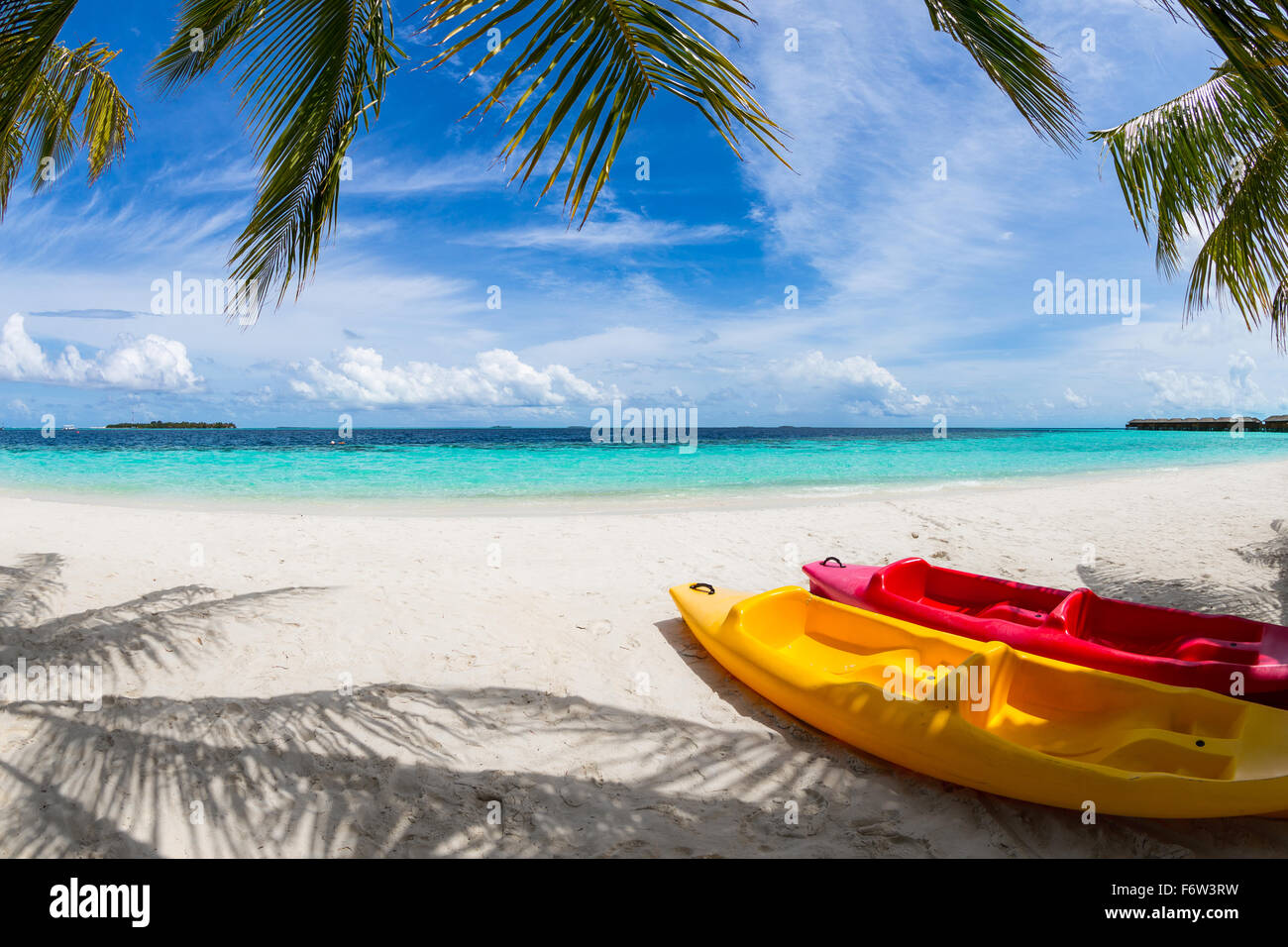 yellow and red kayak on the beach under coco palms Stock Photo - Alamy